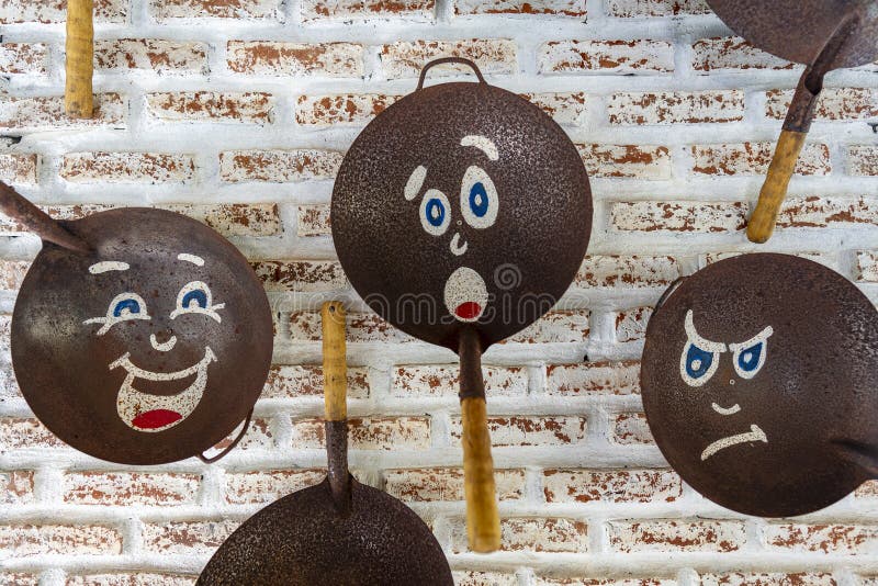 Old Frying Pans with Painted Faces, Hang on a Brick Wall Stock Photo ...