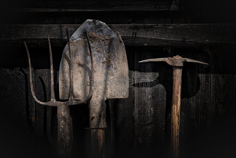 Old Garden Tools in Front of Dark Fence, Pitchfork, Pickaxe and Spade ...