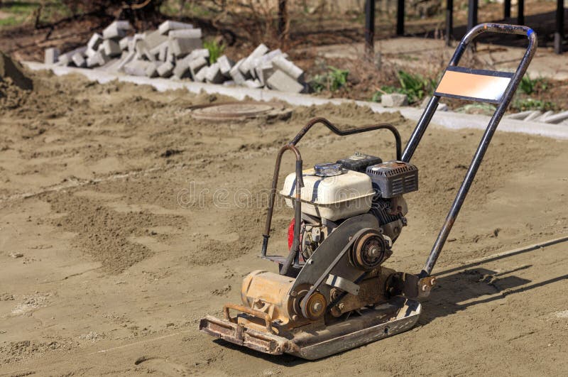 An Old Gasoline Compactor for Compacting Sandy Soil Stands Against the ...
