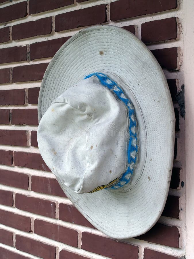 Close-up Old and Dirty White Canvas Hat with Blue Strap Hanging on ...