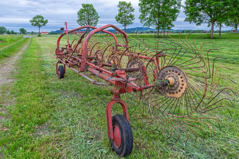 Old hay tedder on a meadow stock image. Image of green - 151044193