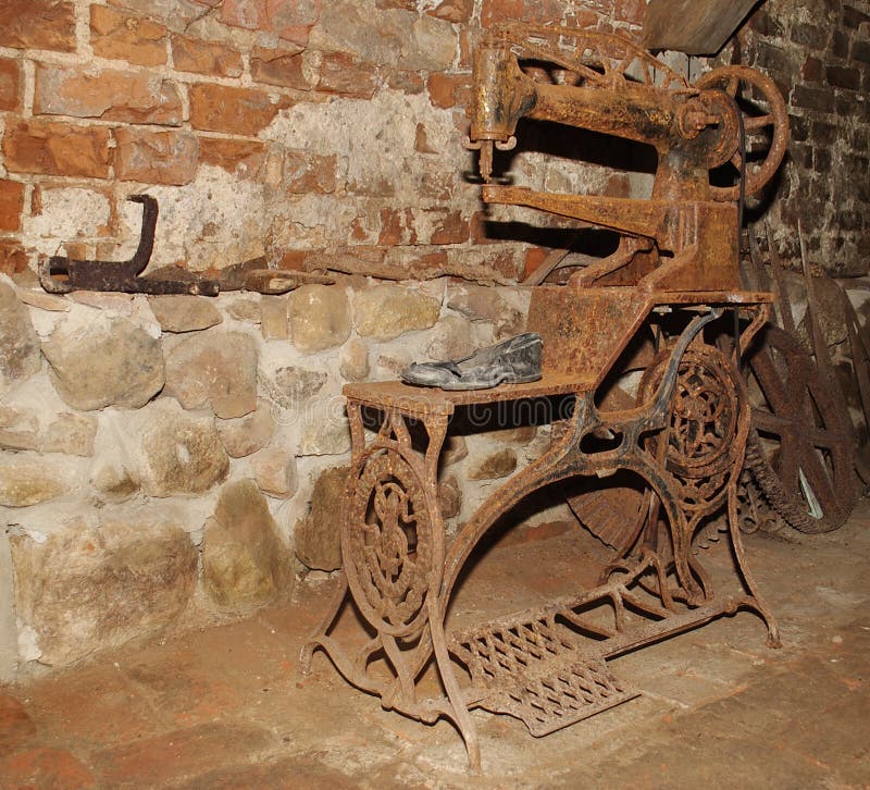 An Old, Historic, Rusty Sewing Machine on a Sewing Machine Table by a ...