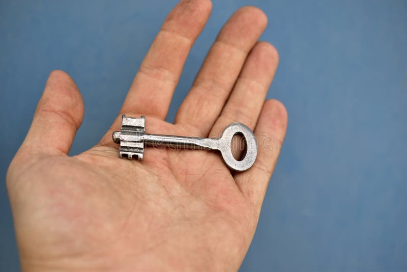 Old Iron Door Key in Hand on Blue Background Stock Photo - Image of ...