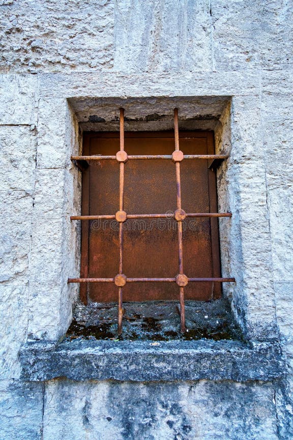 An Old Iron Window with Bars, Rusty, and a White Stone Wall Stock Photo ...