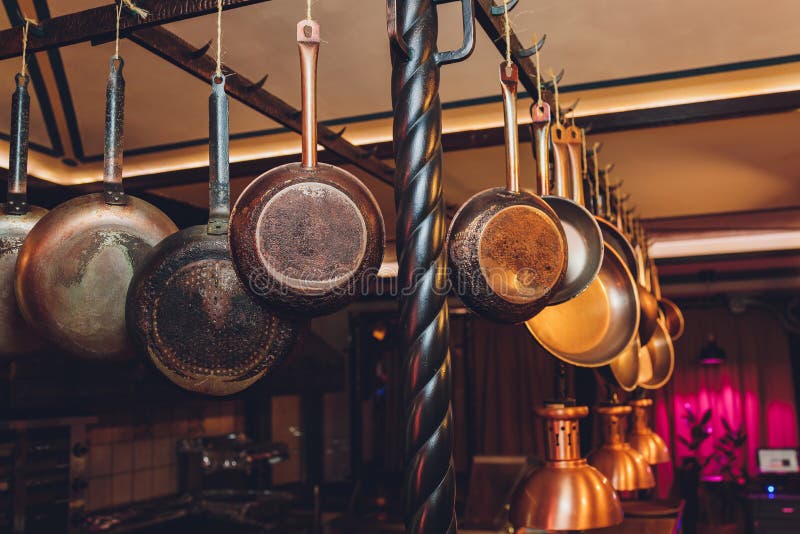 Old Kitchen Pans Hanging on the Bar. Different Size of Pans on the Wall ...