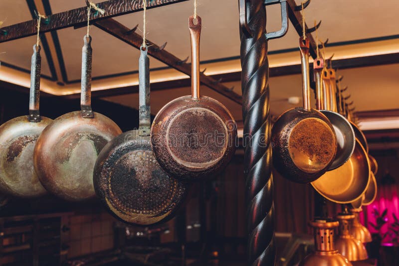 Old Kitchen Pans Hanging on the Bar. Different Size of Pans on the Wall ...
