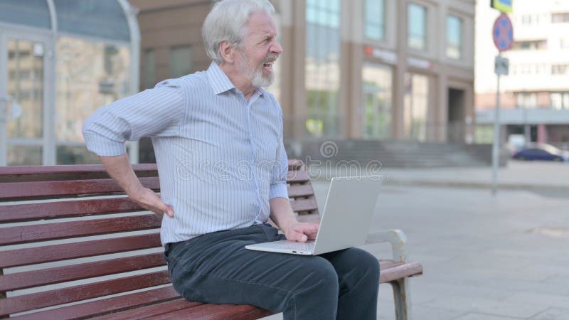 Old Man with Back Pain Using Laptop while Sitting Outdoor on Bench ...
