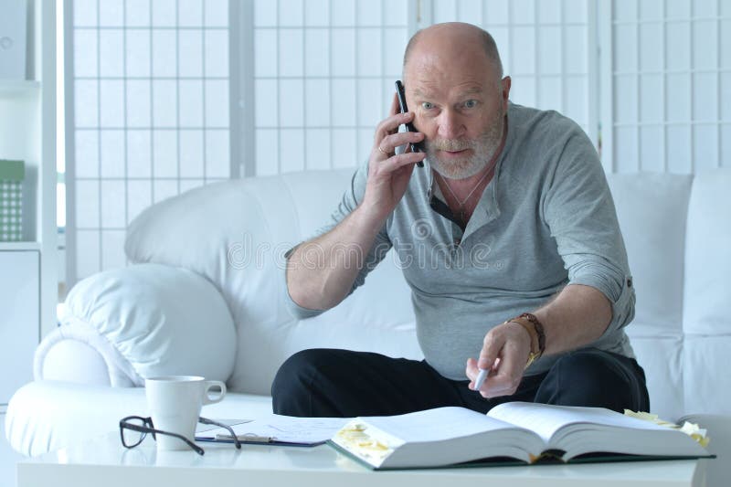 Old Man with Book Talking on Phone and Taking Notes Stock Image - Image ...