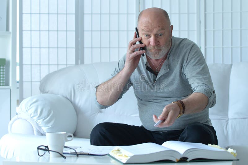 Old Man with Book Talking on Phone and Taking Notes Stock Photo - Image ...