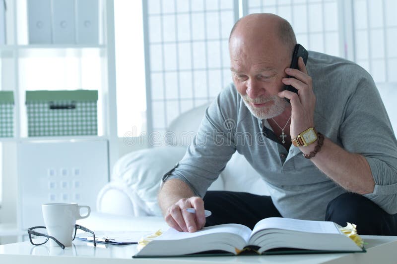 Old Man with Book Talking on Phone and Taking Notes Stock Photo - Image ...