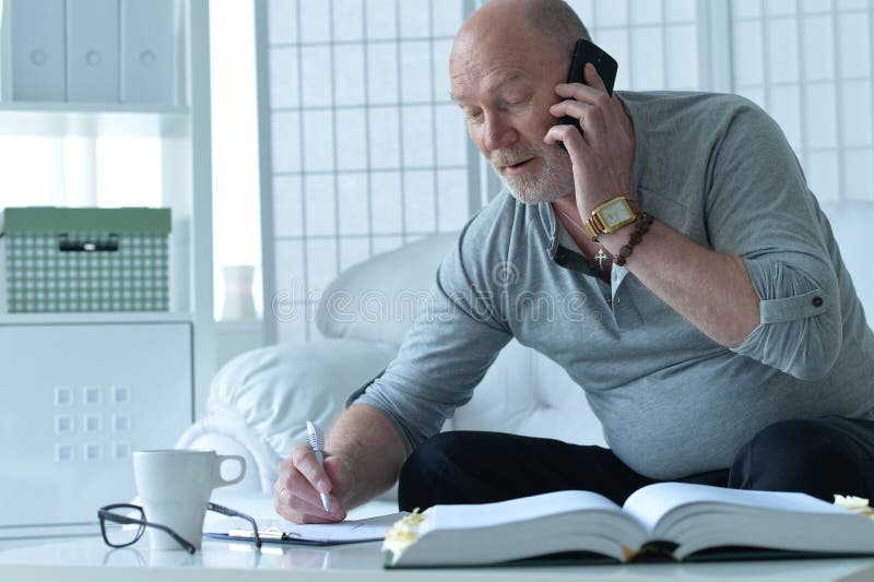 Old Man with Book Talking on Phone and Taking Notes Stock Photo - Image ...