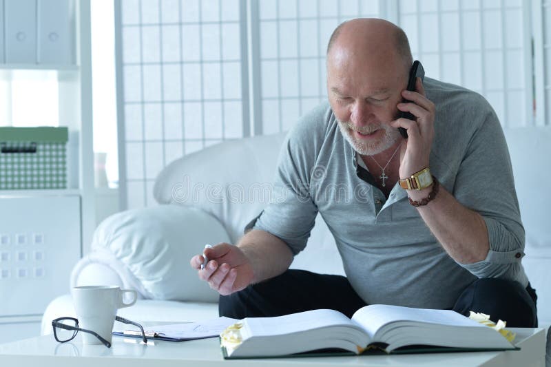 Old Man with Book Talking on Phone and Taking Notes Stock Photo - Image ...