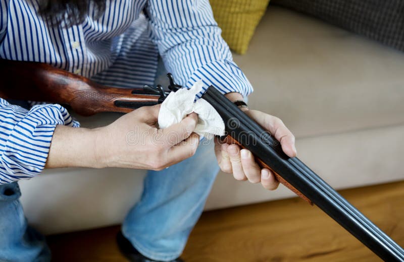 Old man cleaning a gun stock image. Image of clean, dark - 100755937