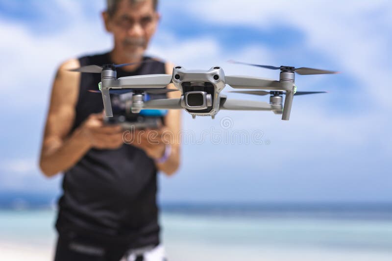 An Old Man Controlling a Small Drone at the Beach. a Hobbyist Drone ...