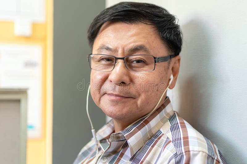 An Old Man Is Happy To Listen To Music Using Headphones Stock Image