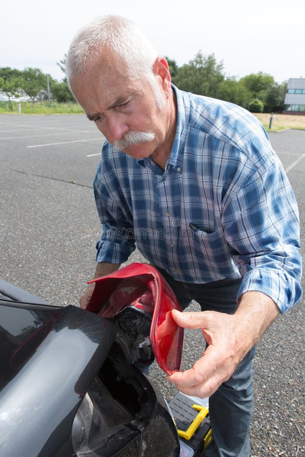 Old Man Installs Tail Light on Vehicle Stock Photo - Image of ...