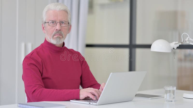 Old Man Looking at Camera while Using Laptop Stock Photo - Image of ...