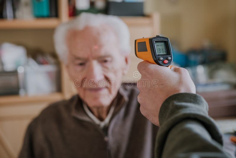 Body Temperature Measurement of a Man in a Medical Mask with a ...
