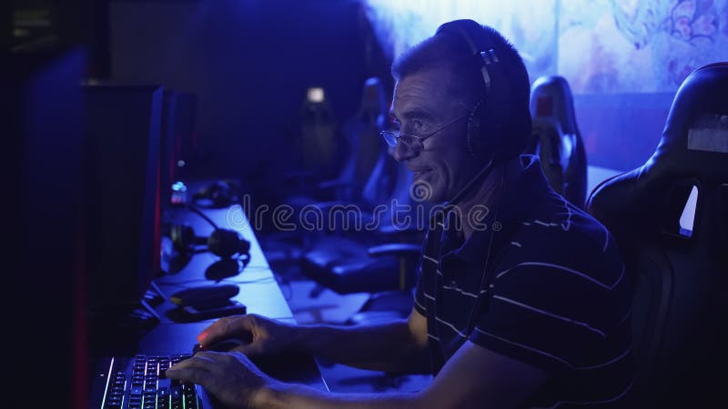 Old Man Playing on Computer Late at Night in Modern Computer Club ...