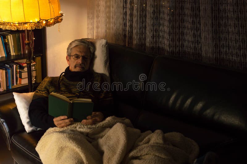 Old Man Reading a Book while Lying on a Sofa Stock Photo - Image of ...