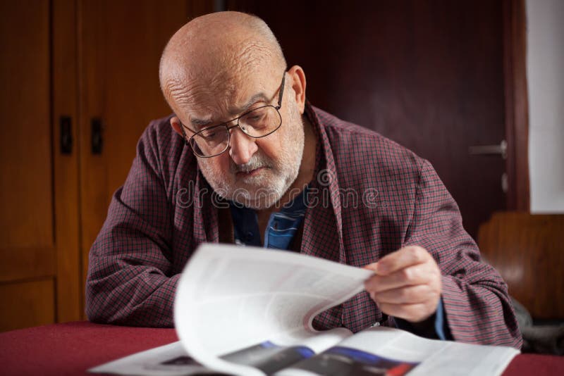 Old man reading magazine stock image. Image of journal - 79353581