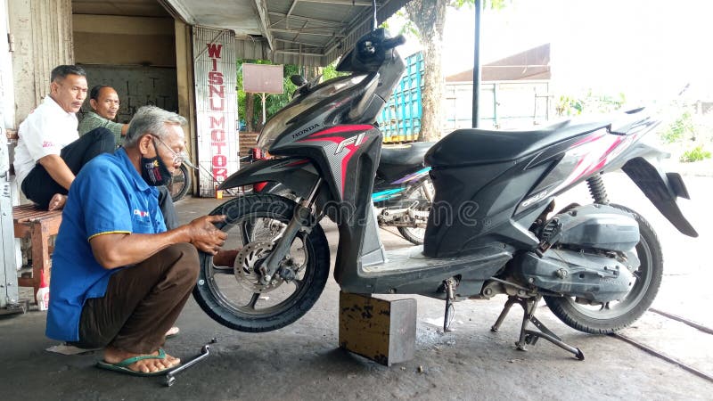 An Old Man Repaired Automatic Motorcycle at a Repair Shop Editorial ...