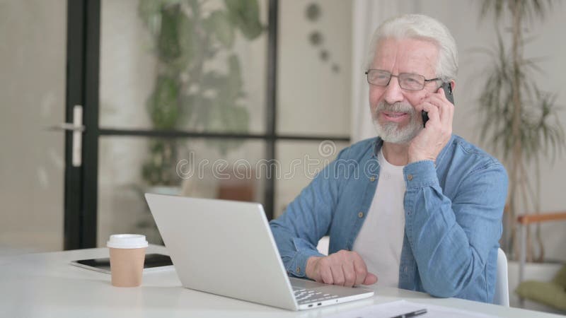 Senior Old Man Talking on Phone while Using Laptop Stock Photo - Image ...