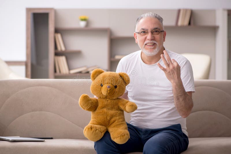 Old Man with Toy Bear at Home Stock Image - Image of sofa, retire ...