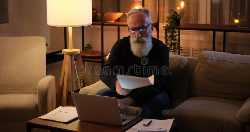 Old Man Using Laptop and Analyzing Documents Late Night Stock Footage ...