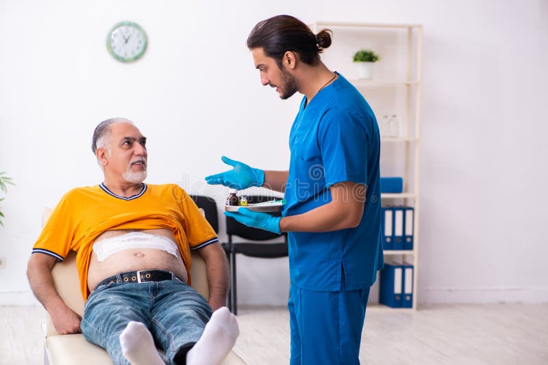 Old Man Visiting Young Male Doctor Stock Photo - Image of clinic ...