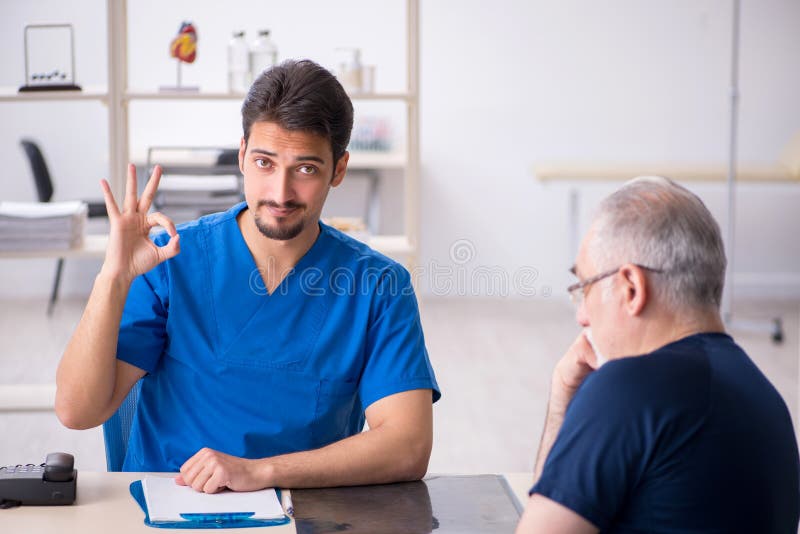 Old Man Visiting Young Male Doctor Stock Photo - Image of physician ...