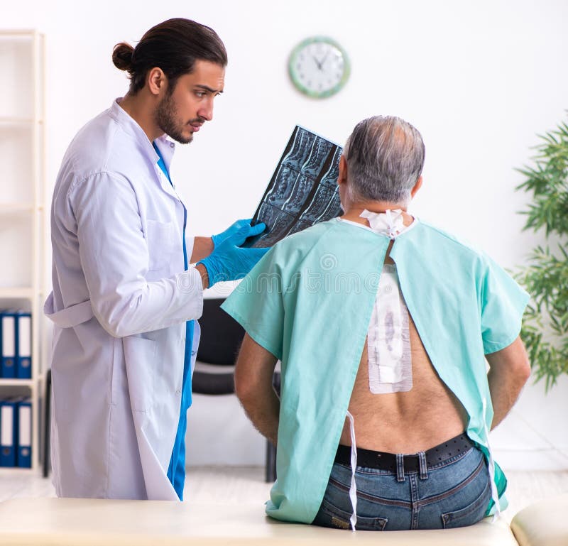 Old Man Visiting Young Male Doctor Stock Photo - Image of clinic ...