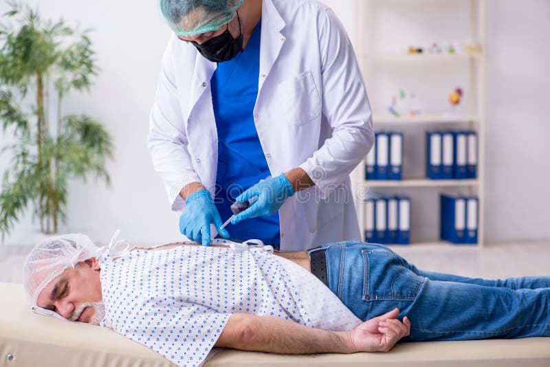 Old Man Visiting Young Male Intern Doctor Stock Photo - Image of ...