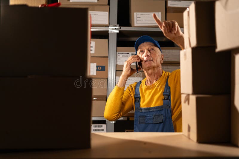 Old Man Worker Talking on a Mobile Phone To Checking Inventory in the ...