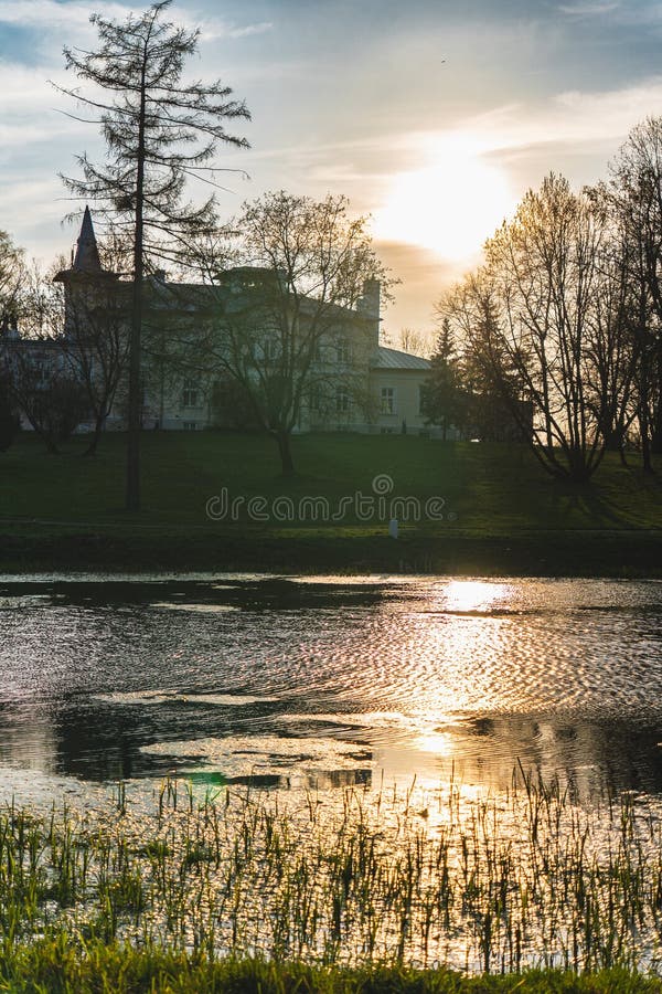 Old Manor House on a Grassy Hill on the Shore of the Lake during Sunset ...