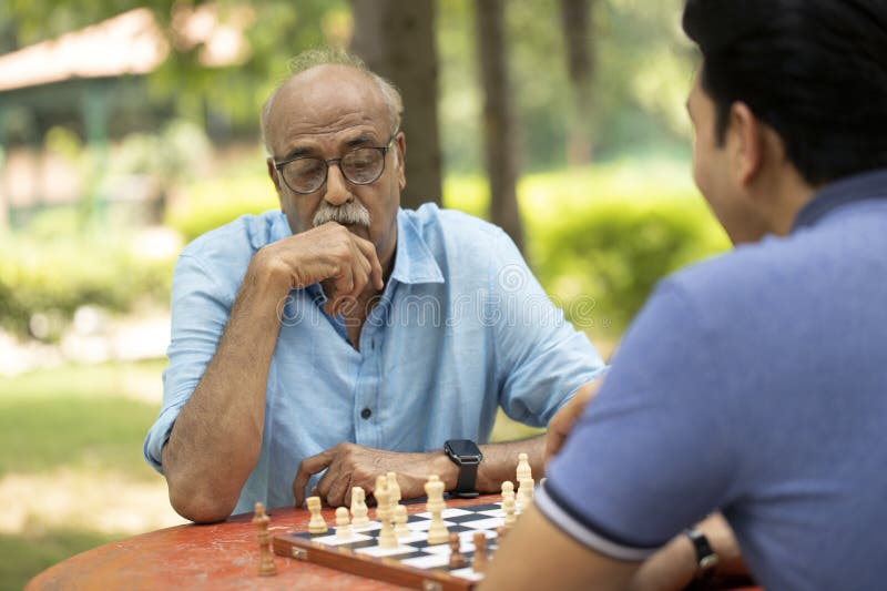 Old Man Playing Chess and Deeply Engaged in Game with Son Stock Image ...