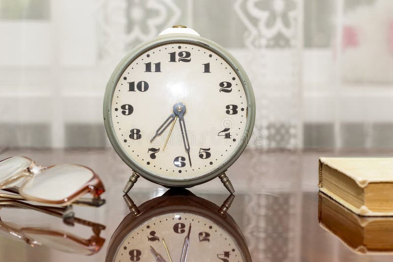 Old Metal Alarm Clock, Glasses, a Book on a Polished Table with Stock ...