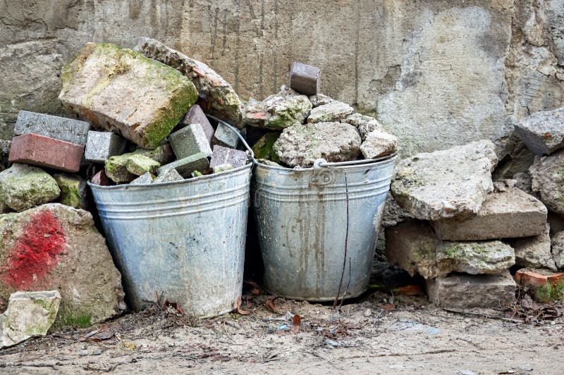 Old Metal Buckets among Aged Bricks Filled with Small Broken Brick ...