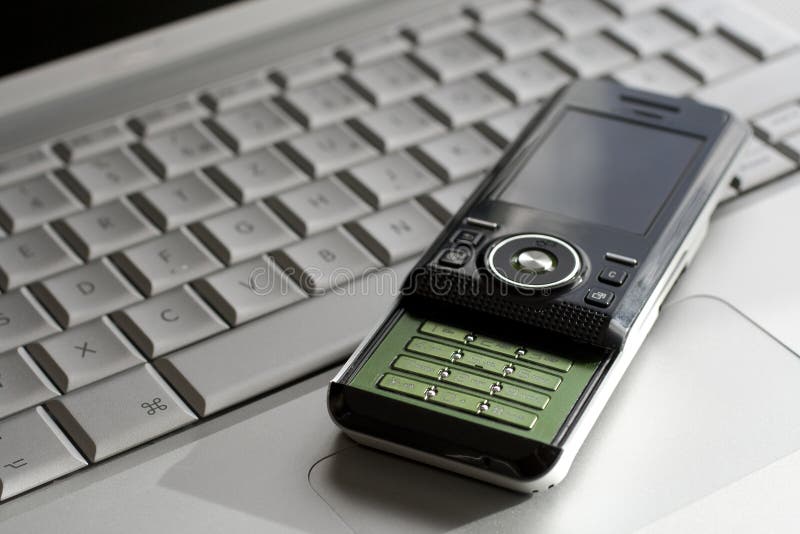 Old Mobile Phone on a Silver Laptop Stock Photo - Image of blank ...