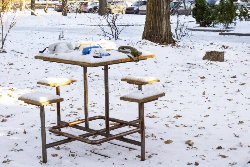 Old Models of Phones on a Table in the Yard. Snow on the Table and on ...