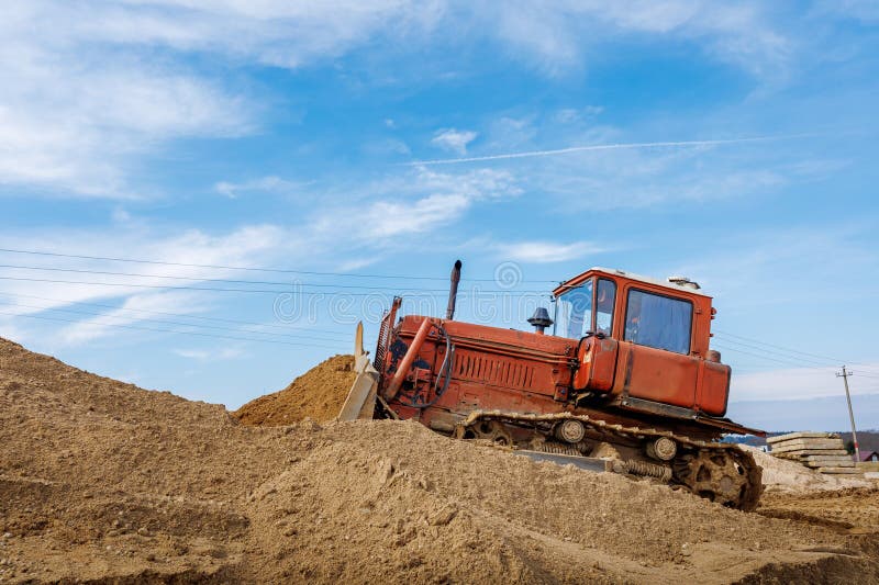 An Old Orange Bulldozer Performs Work To Level the Sandy Soil Stock ...