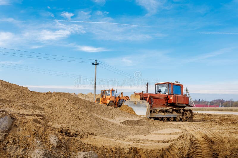 An Old Orange Bulldozer Performs Work To Level the Sandy Soil Stock ...