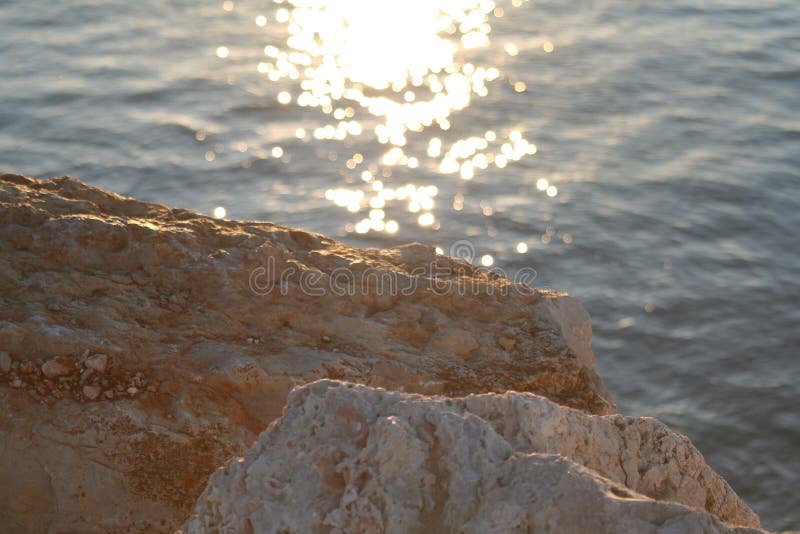 Old and Patterned Rocks and the Wavy Ocean Gleaming Under the Sunrays ...