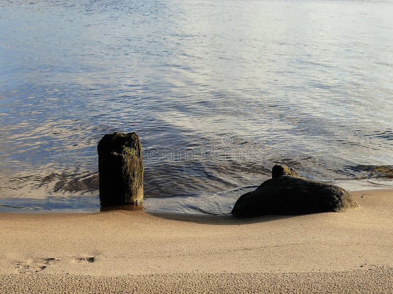 Old Piles and Stone on Sandy River Beach Stock Photo - Image of sand ...