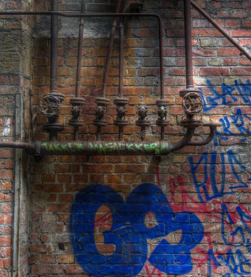 Old Pipes with Valves on a Wall with Graffiti Stock Photo - Image of ...