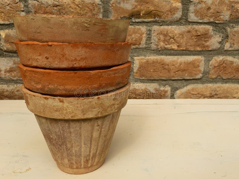 Used Terracotta Pots Stacked Upside Down on a White Table with Brick ...