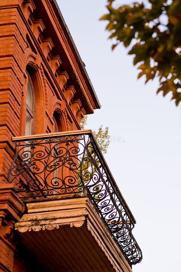 An Old Red Brick Building with a Wrought Iron Balcony Stock Image ...
