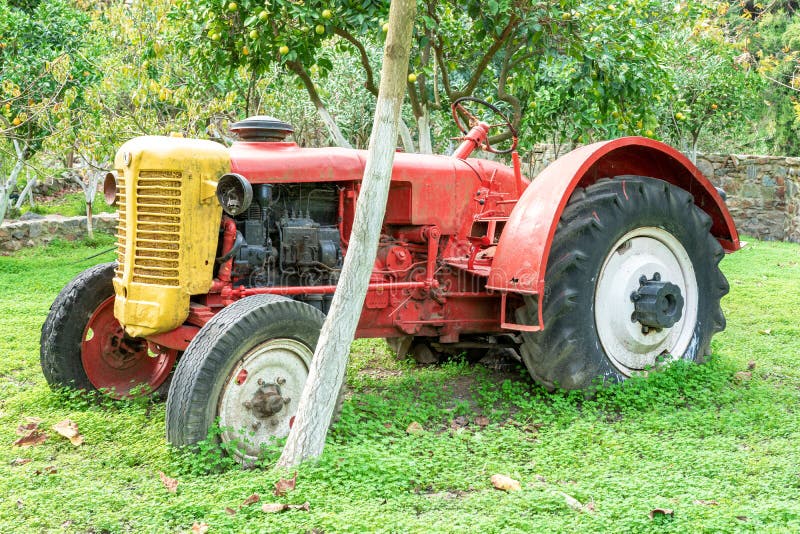 A Old Red Rusty Tractor in the Garden with Trees Stock Image - Image of ...