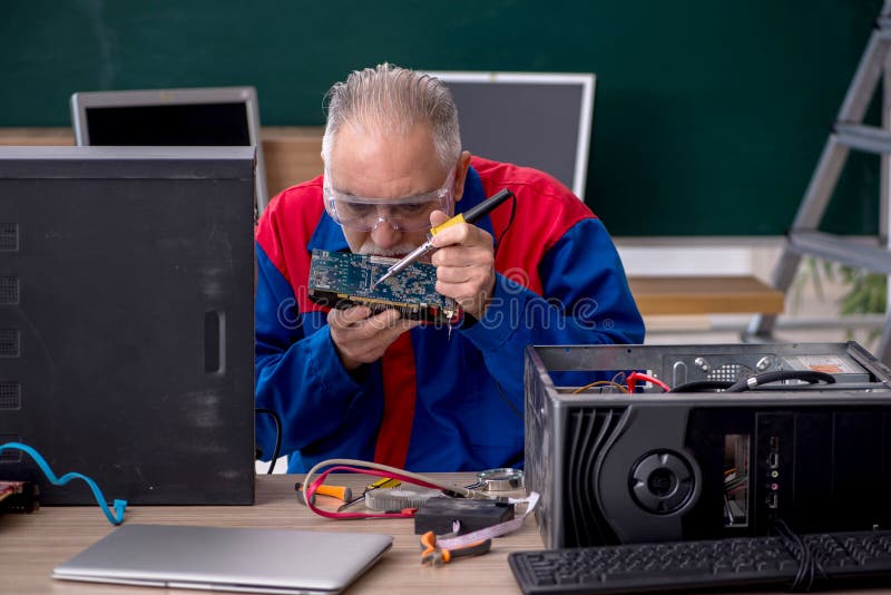 Old Repairman Repairing Computers in the Classroom Stock Photo - Image ...