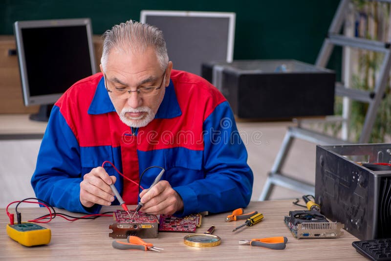 Old Repairman Repairing Computers in the Classroom Stock Photo - Image ...